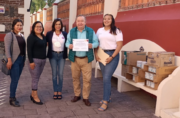 Donación de latas de leche por Fundación de Beneficencia Privada "Cáritas de Puebla".